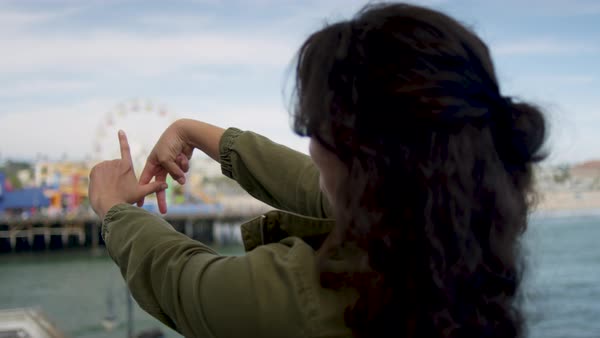Portrait Of Young Woman Making An LA Hand Symbol, She Turns And Smiles ...