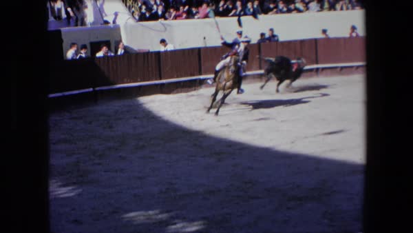 1971: a bull chasing a man with a flag on a horse around a ring - Stock ...