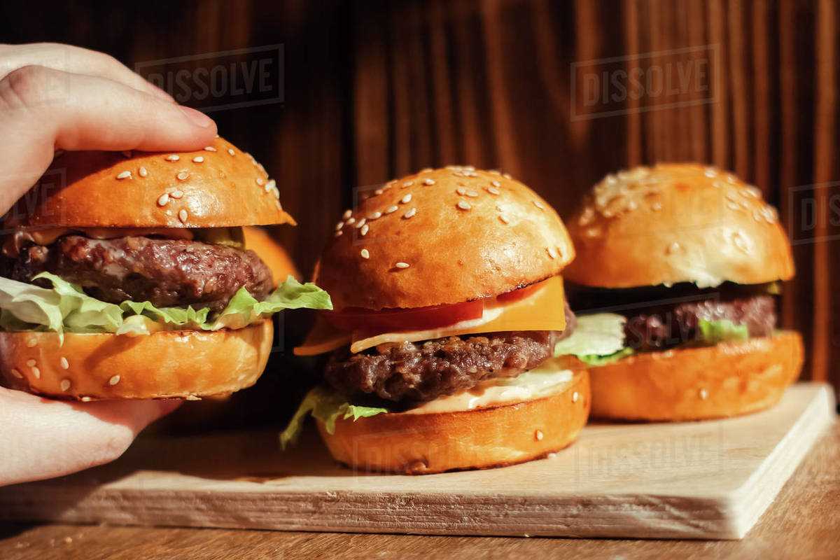 Mini burger on a stand close-up. Children fast food in a restaurant or ...