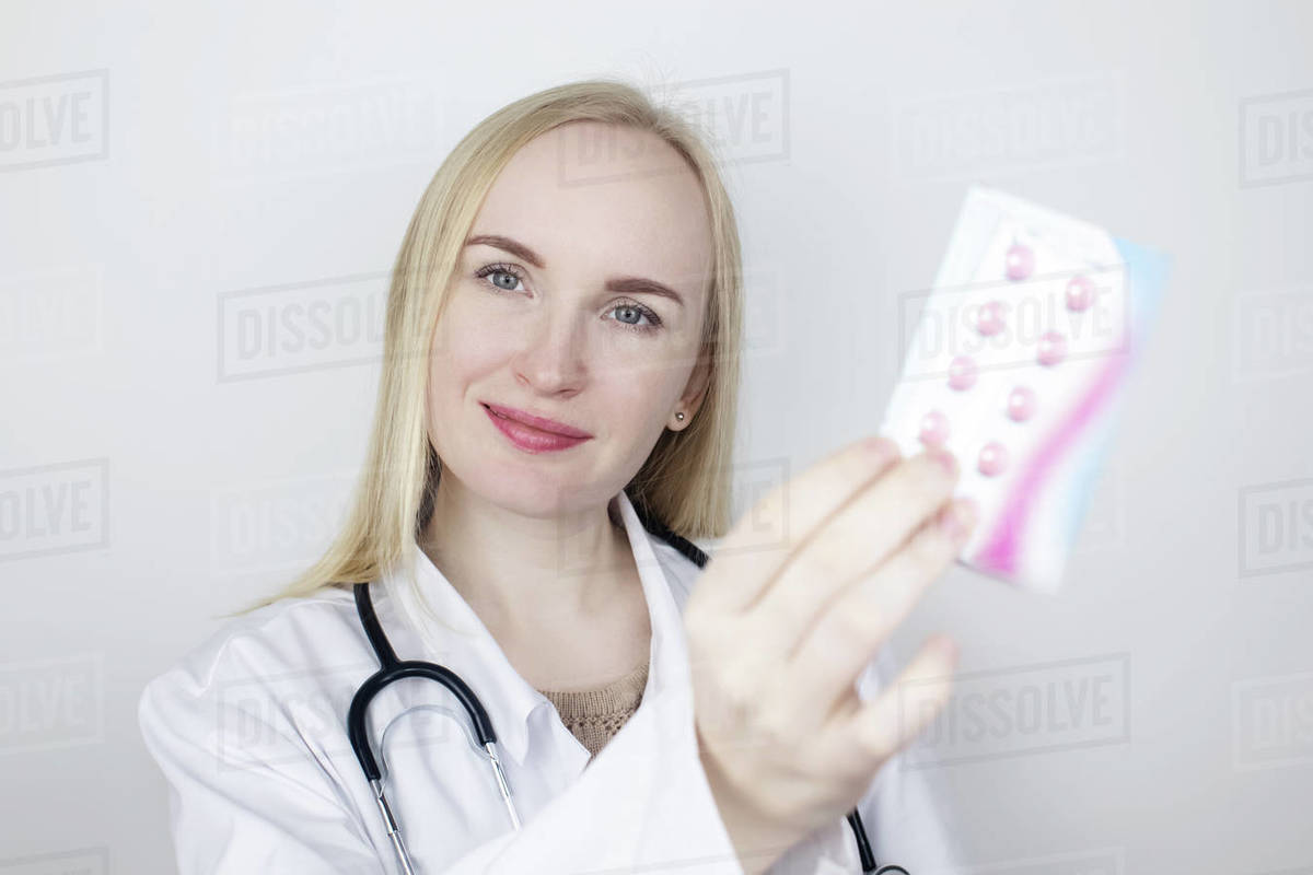 A specialist in a white coat holds pills in his hand. Recommendations ...