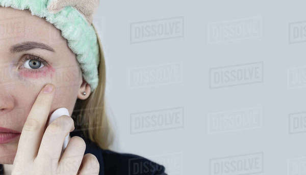 Allergy to cosmetics. The girl looks at the pimples around her eyes ...