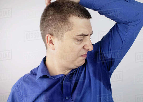 The man shows his sweaty armpits to the camera. Close-up of sweat drops ...