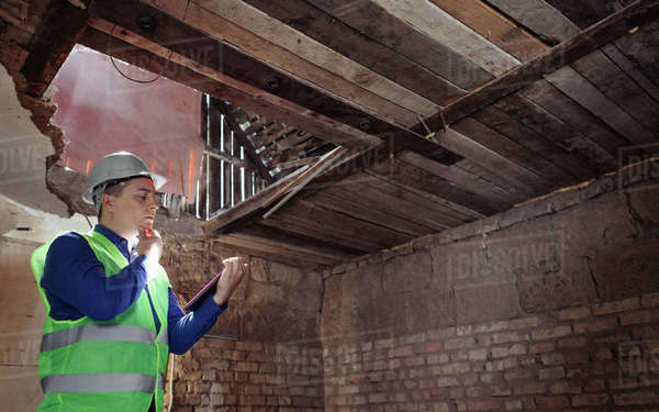 Building inspector. Man in a hard hat and a yellow reflective vest ...