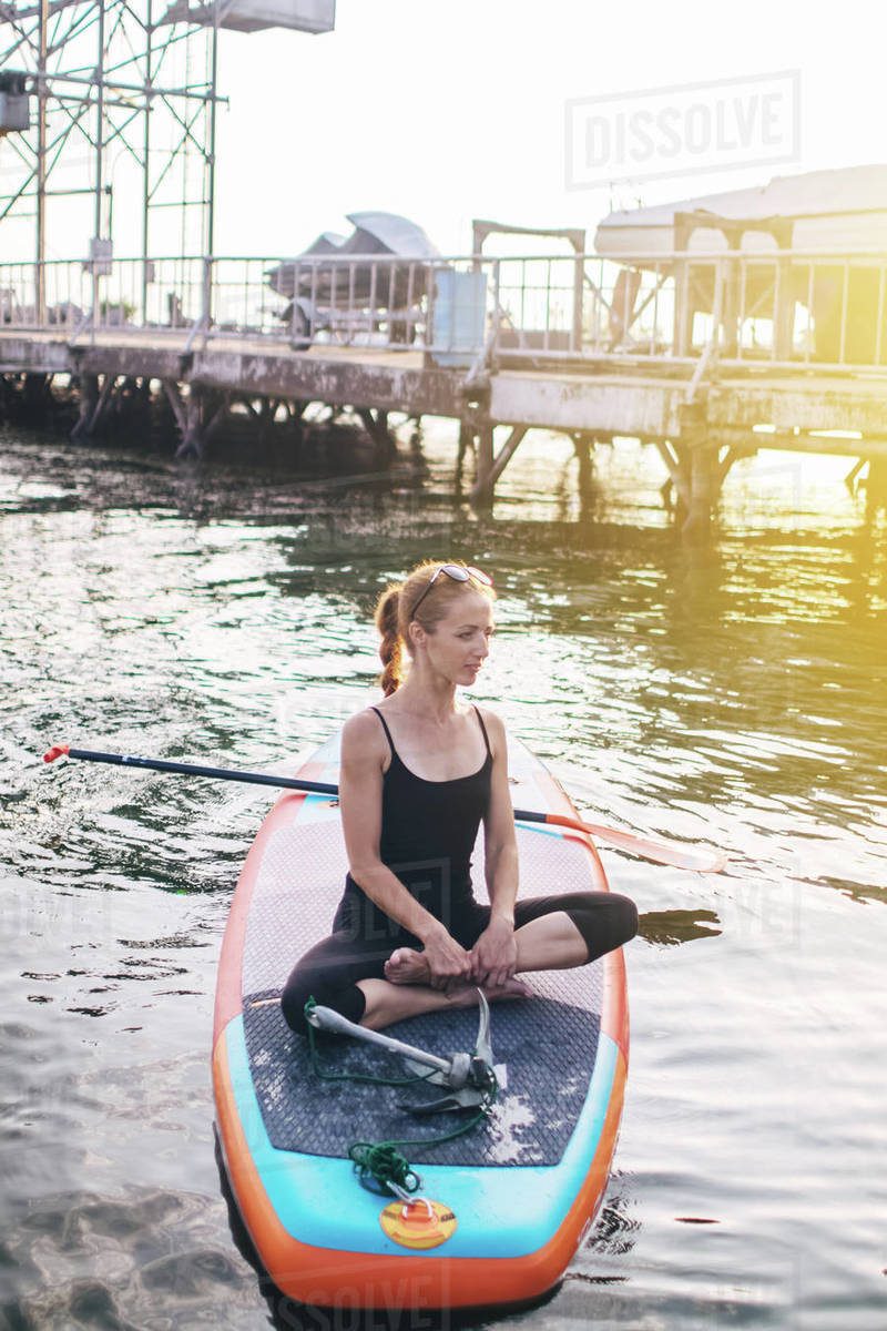 Close-up of a girl doing yoga on sub board. Psychology meditation ...