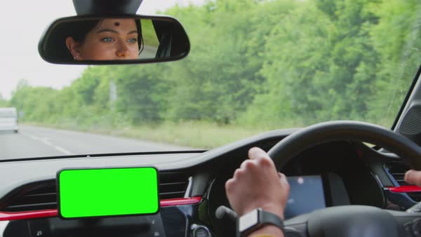 Close up of woman driving car with hands free unit for green screen ...
