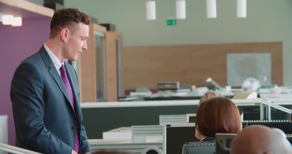 Manager walking through open plan office talking to staff - 4K Royalty ...