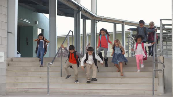 A group of energetic elementary school kids leaving school - Stock ...