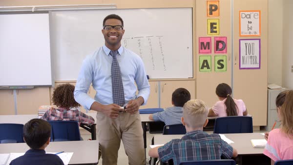 Happy male teacher walking through class toward camera - 4K Royalty ...