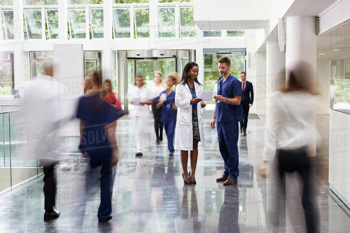 Staff in busy lobby area of modern hospital - Stock Photo - Dissolve