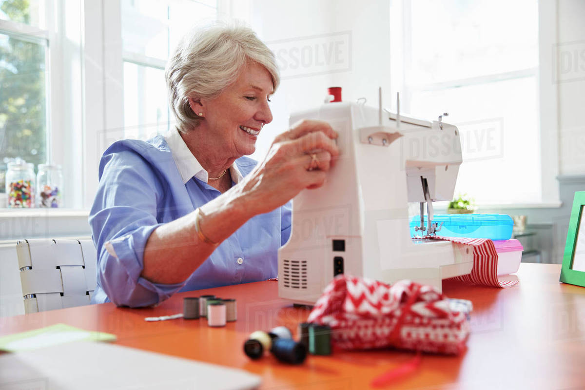 Senior Woman Making Clothes Using Sewing Machine At Home - Royalty-free ...