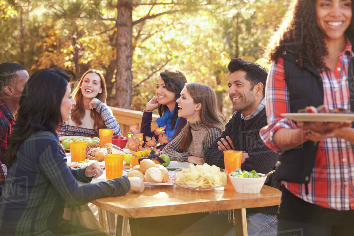 Friends at a barbecue laughing at table, woman in foreground - Stock ...