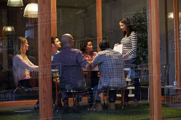 Late night meeting around table in design office - Stock Photo - Dissolve