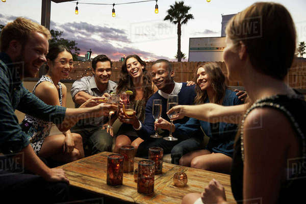 Group of friends enjoying night out at rooftop bar - Royalty-free Stock ...