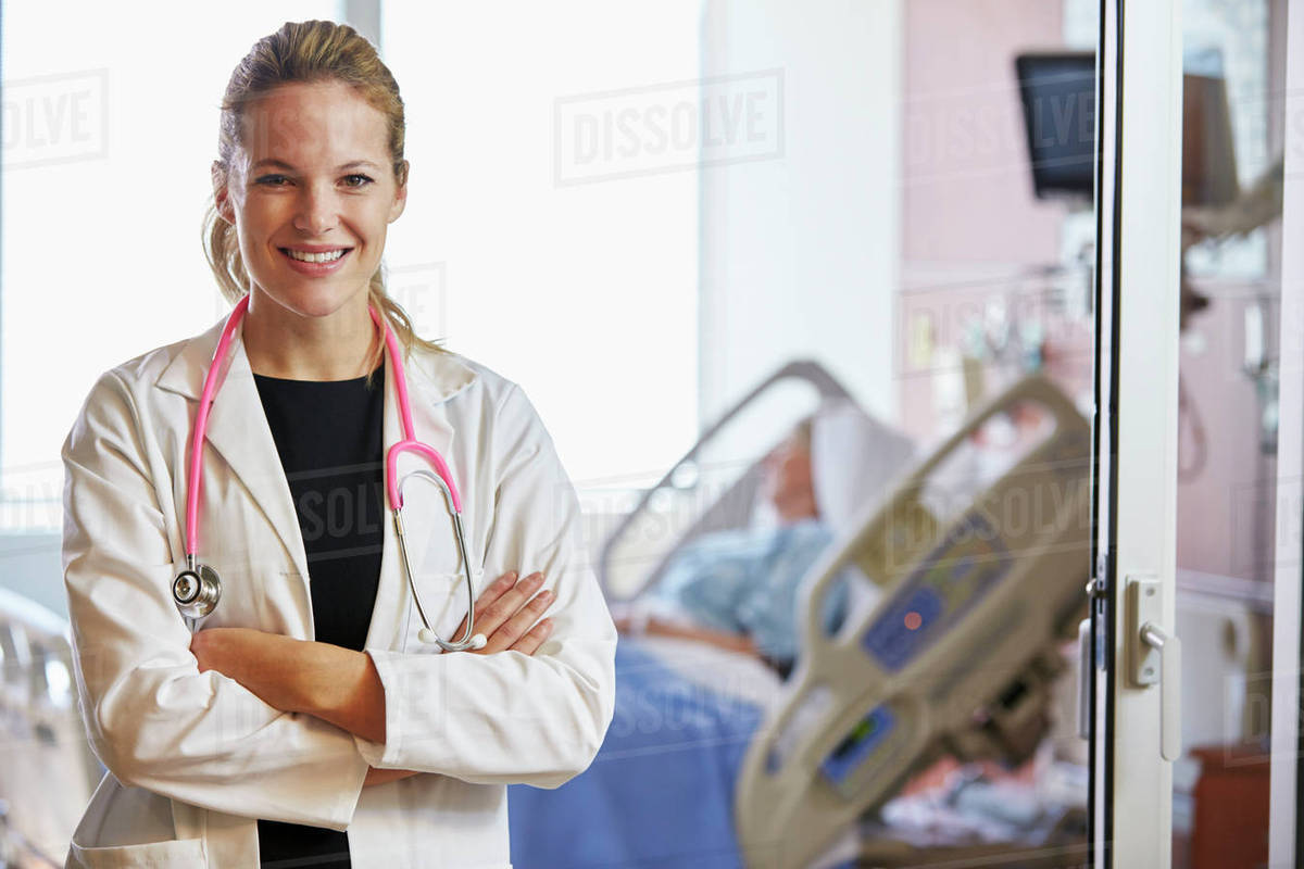 Portrait of female doctor with patient in background - Stock Photo ...
