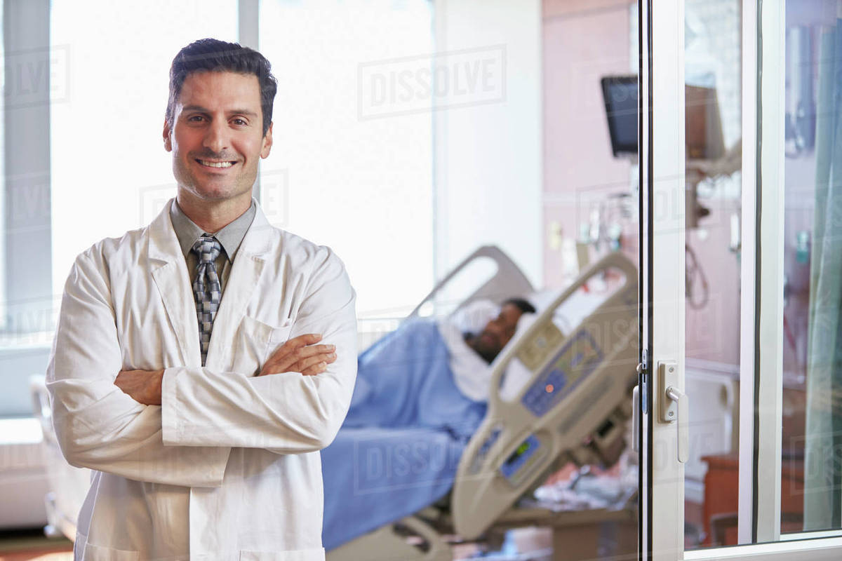 Portrait of male doctor with patient in background - Stock Photo - Dissolve