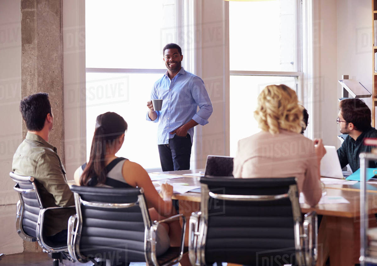 Businessman Addressing Team Meeting Around Table - Stock Photo - Dissolve