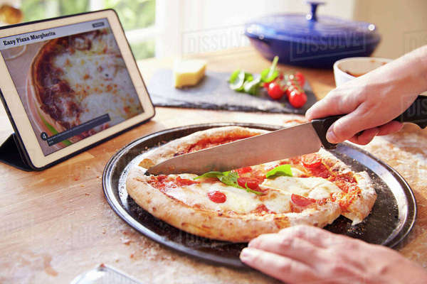 Person following pizza recipe using app on digital tablet - Royalty ...