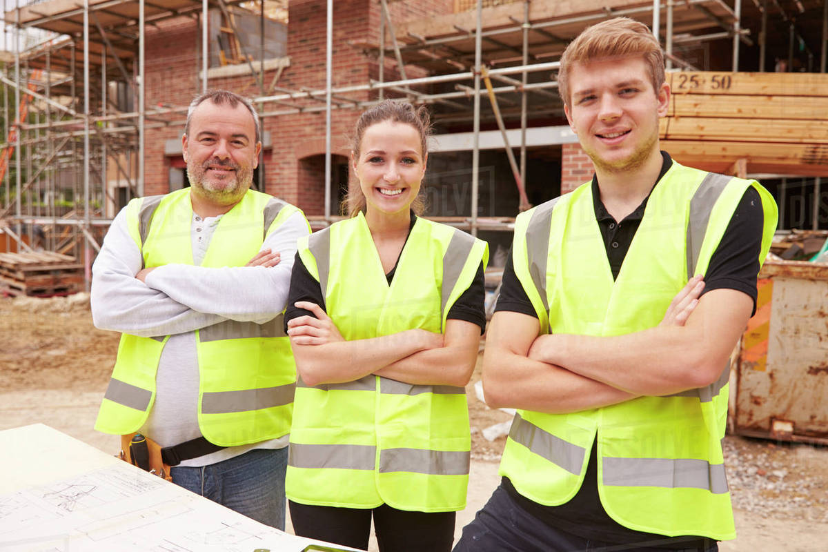 Portrait of builder on building site with apprentices - Royalty-free ...