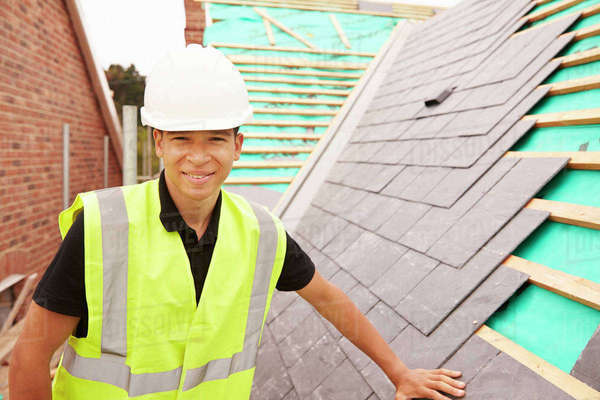 Construction worker on building site laying slate tiles - Royalty-free ...