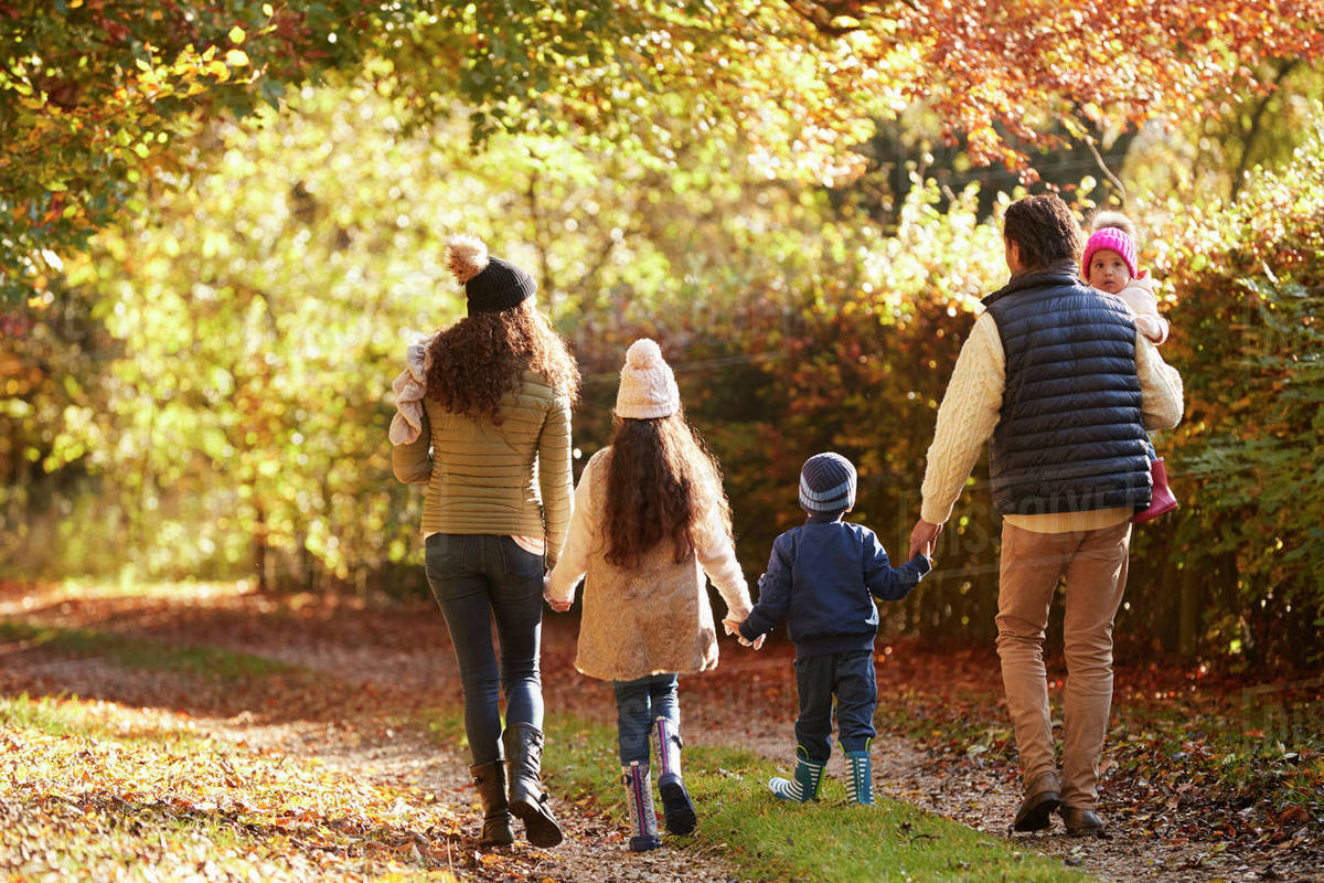 Rear view of family enjoying autumn walk in countryside - Royalty-free ...