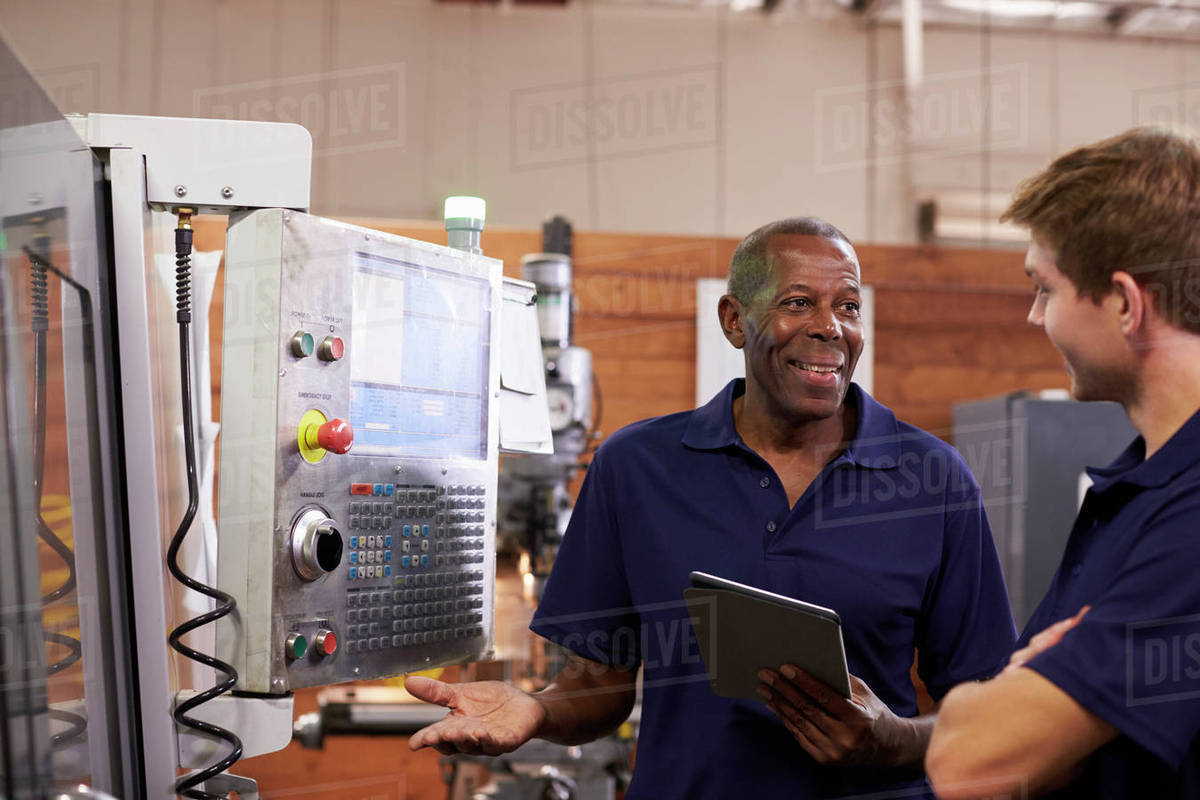 Engineer training male apprentice on CNC machine - Royalty-free Stock ...