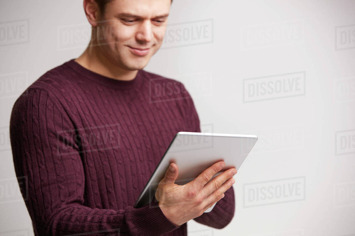 Smiling young white man using a tablet computer - Royalty-free Stock ...