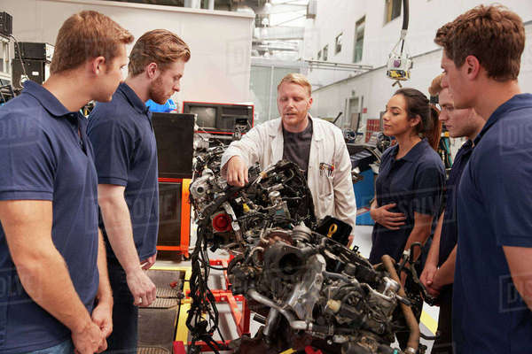 Mechanic showing parts of an engine to apprentices, close up - Royalty ...