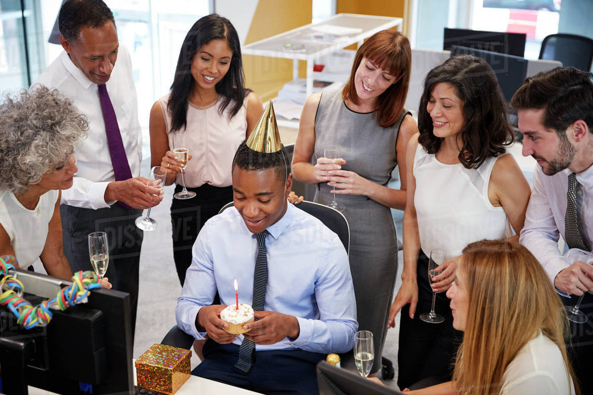 Colleagues gathered at a man’s desk to celebrate a birthday - Royalty ...