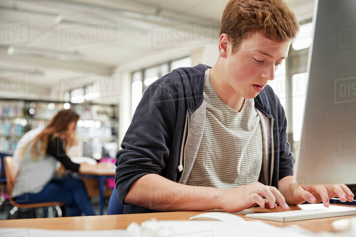 Male Student Working On Computer In College Library - Royalty-free ...