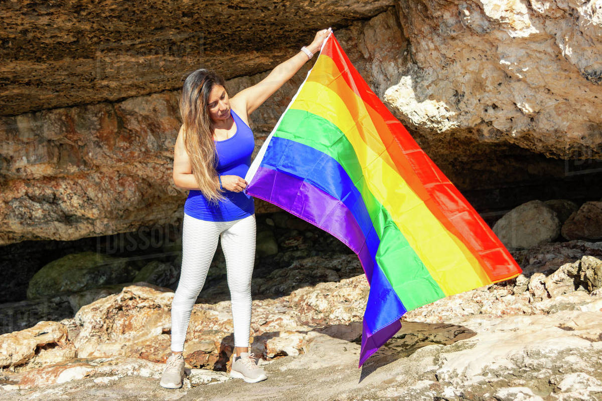 woman, middle aged, outdoors waving pride flag, concept of libertat ...