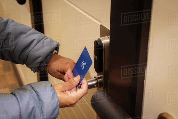 Woman hand using electronic smart key card to unlock door in hotel or ...