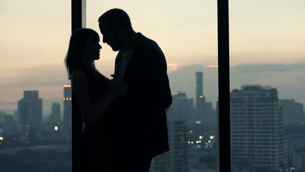 Sad, offended couple standing by window at home at night - Stock Video ...