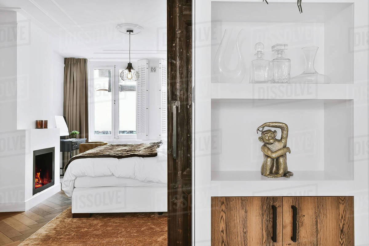 Stylish shelf with a figurine of a monkey next to the door to the ...