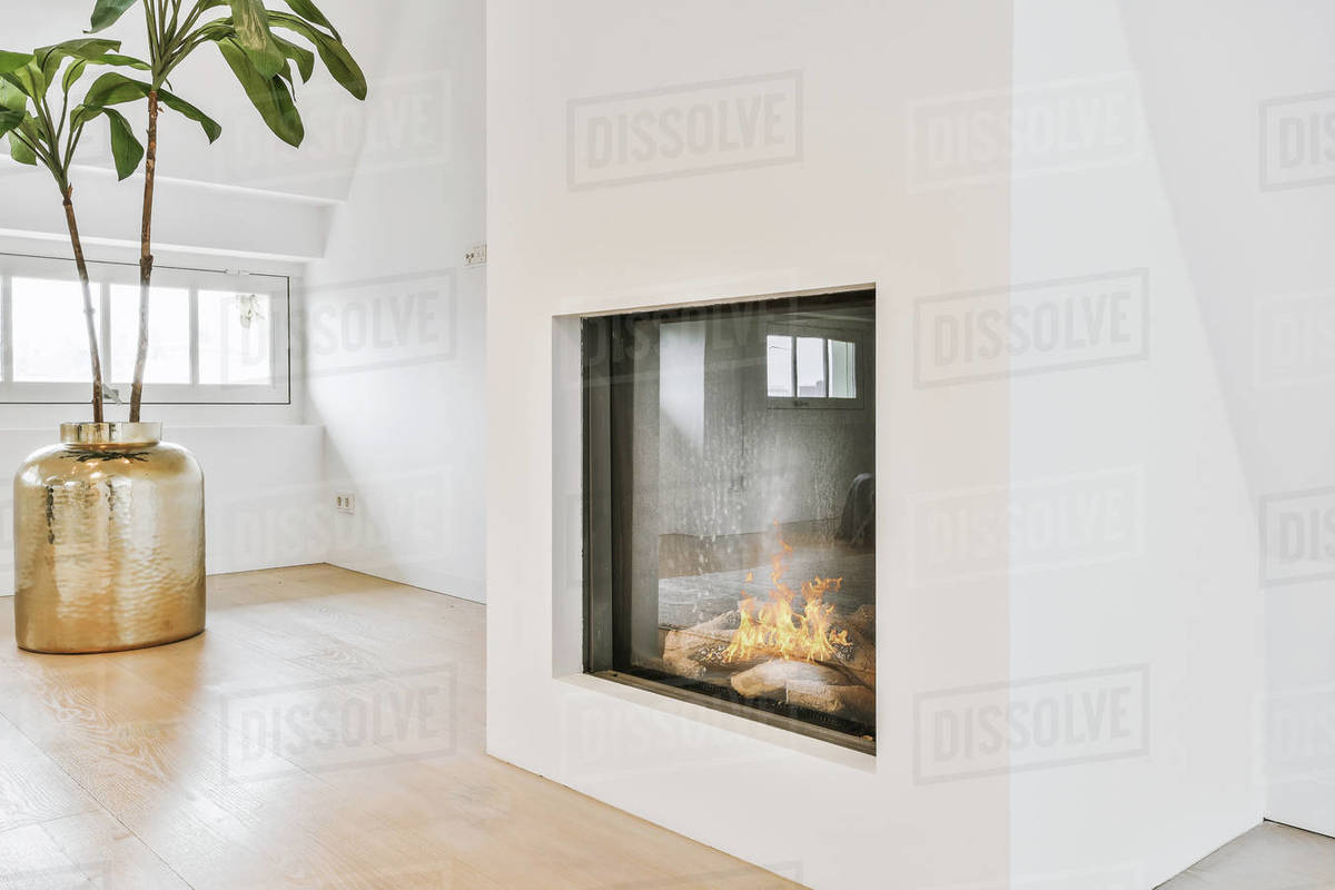 Modern glass fireplace with burning fire built in white wall of modern ...