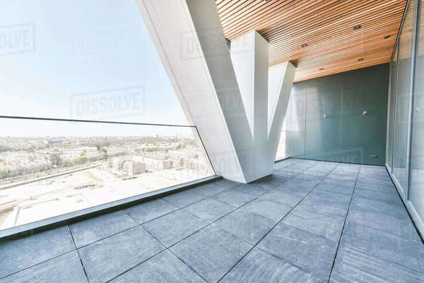 Balcony of luxury apartment in high rise building with glass fence and ...