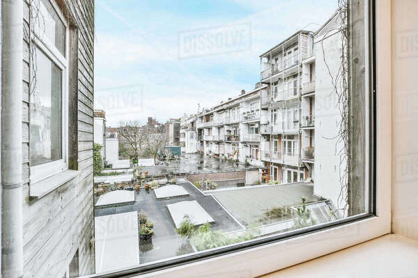 Through window view of city district with residential apartment ...