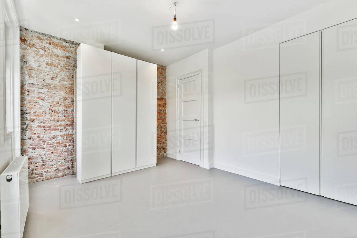 Interior of loft room with minimalist style wardrobe located near ...