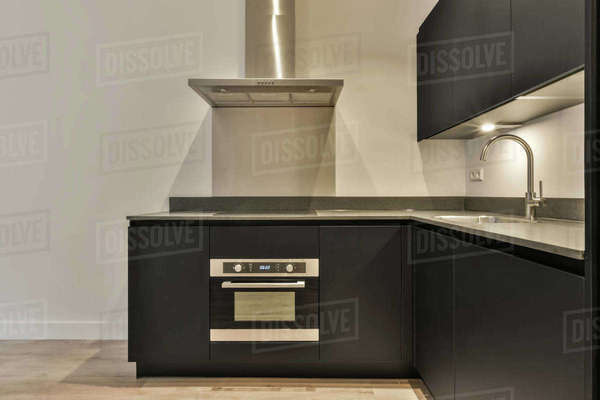 Modern kitchen with black kitchen unit and parquet floor - Royalty-free ...