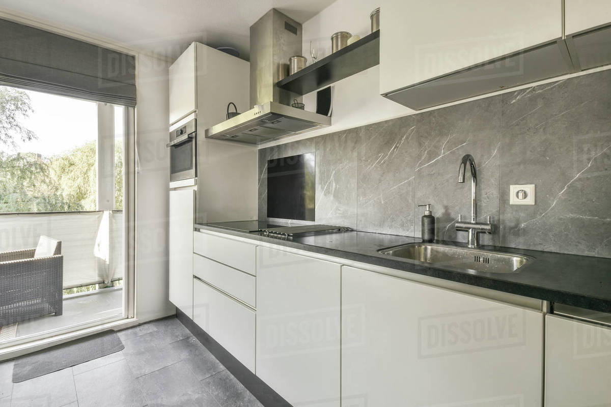 Luxury kitchen in shades of gray with a worktop and high-legged chairs ...
