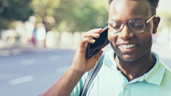 Hello, phone call and black man in a city walking, talking and happy ...