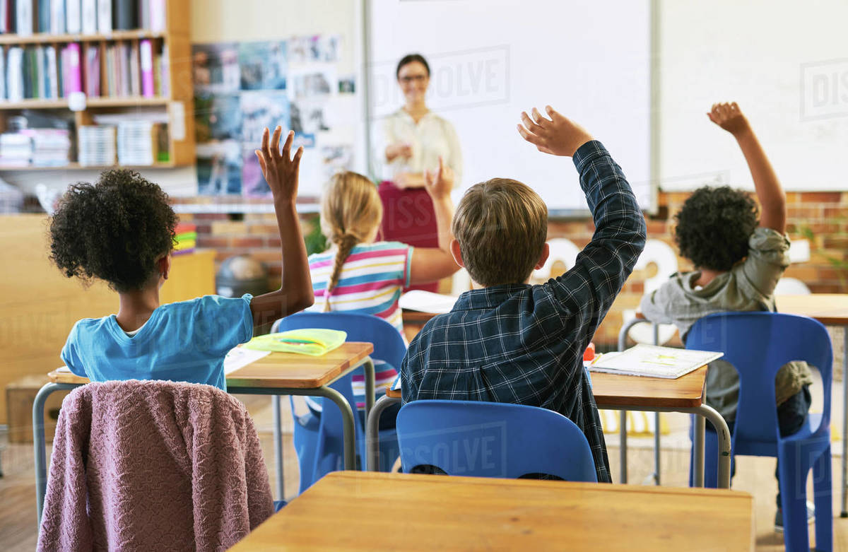 Education, question with group of children in classroom and raise their ...
