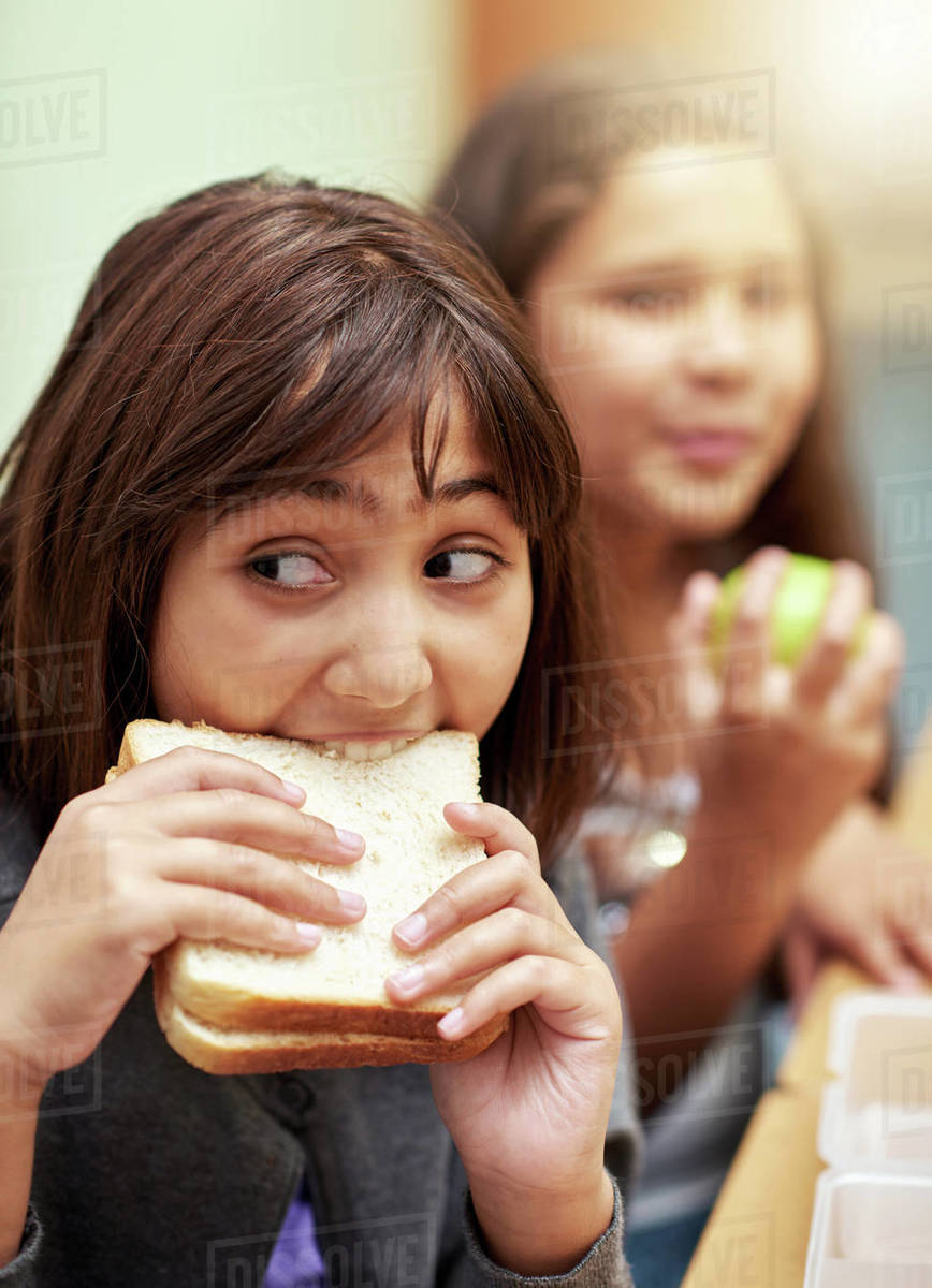 Girl, face and student biting sandwich for meal, break or snack time in ...