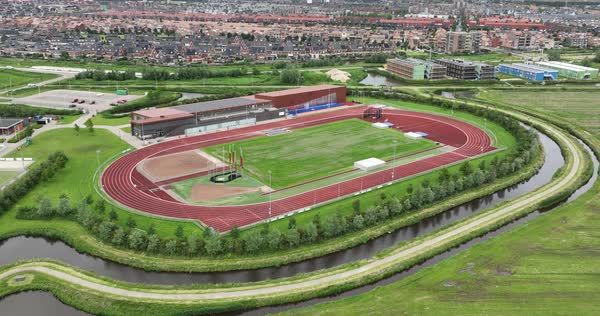 Oval Running Track A Lone Athlete Runs In The Outer Lane Of An Outdoor