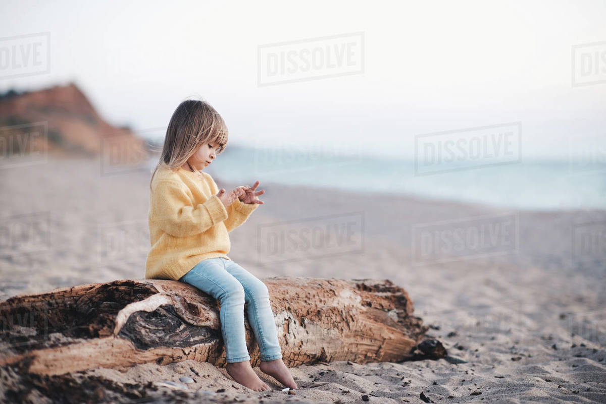 Pretty little child playing at beach over sea at background. - Stock ...