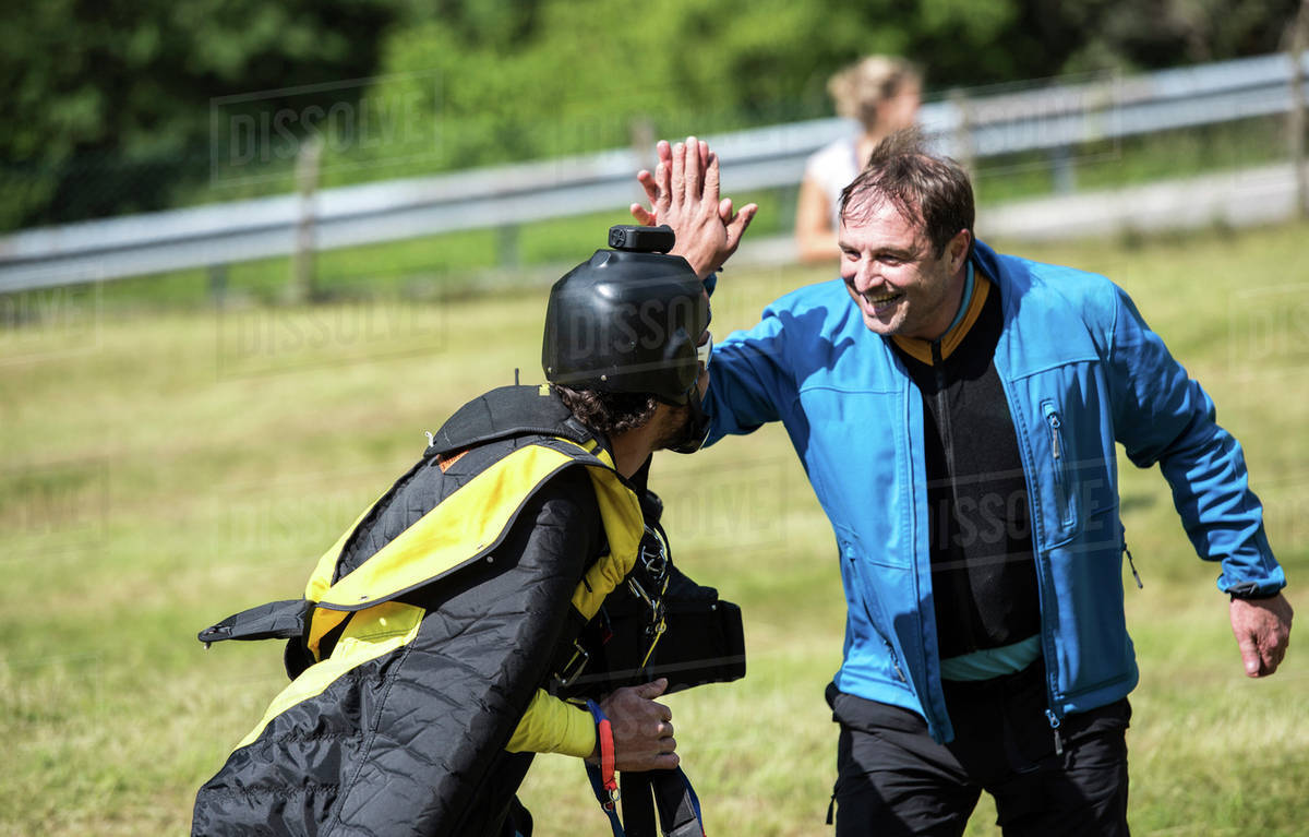 Two men high-fiving each other after landing - Royalty-free Stock Photo ...
