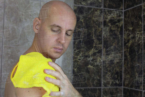 Man without hair washes himself in shower with washcloth, bald guy ...