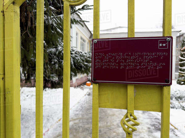 Red sign in braille text with information about building in front of ...
