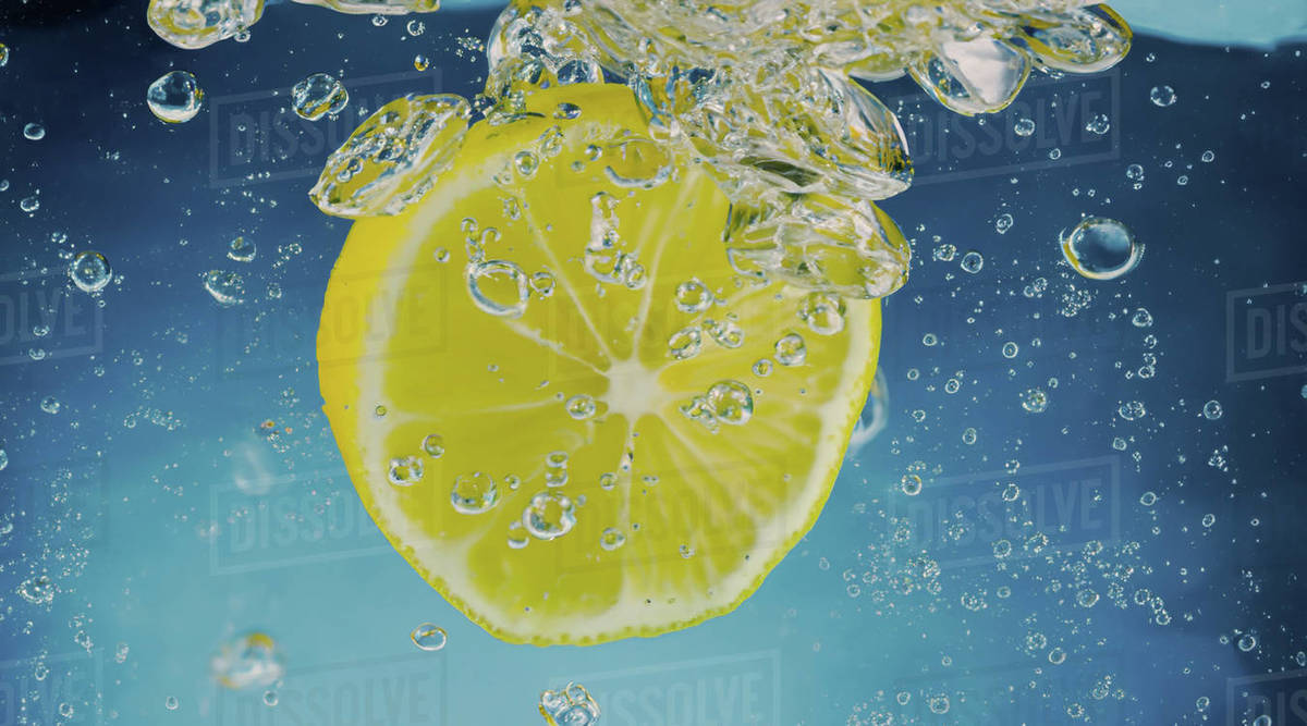 Underwater lemon slice in soda water or lemonade with bubbles. Refreshing soda tonic fizzy ...