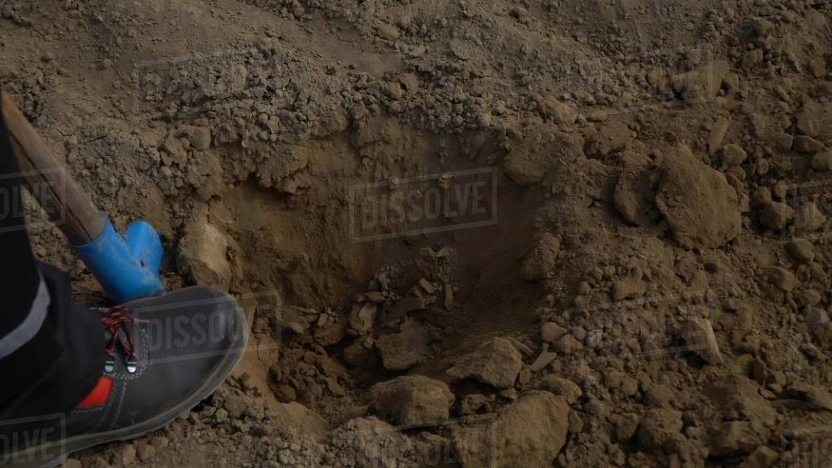 Shovel digging hole in the ground. Close up - Stock Photo - Dissolve