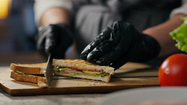 Toast, Fry Cook intently Cuts a crispy sandwich with a knife in a ...